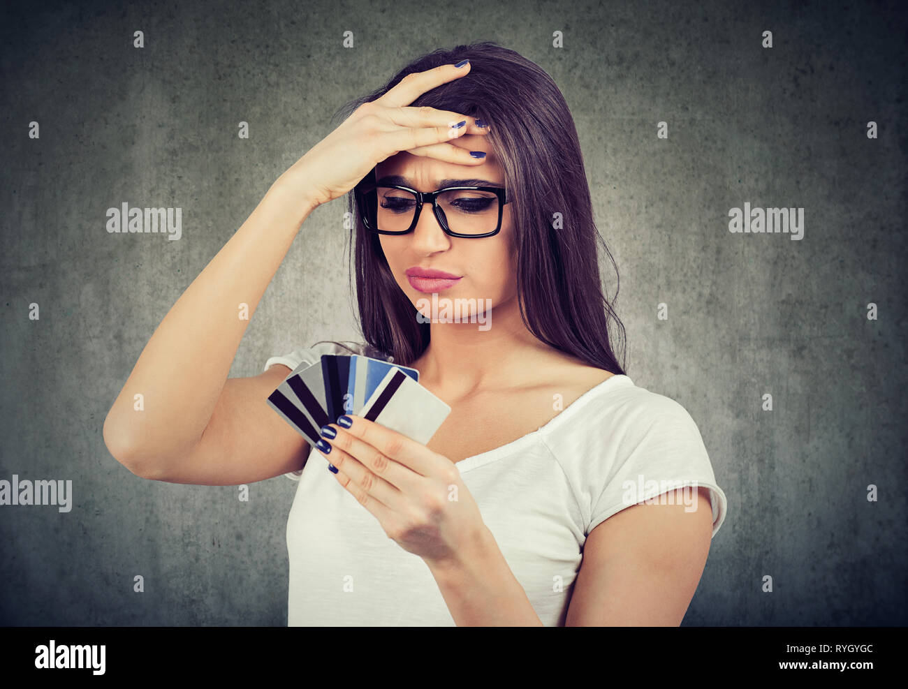 Confused stressed woman looking at too many credit cards full of debt ...