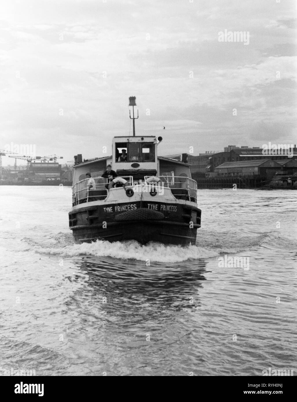 Mid Tyne ferry, Tyne Princess, with river Tyne factories and cranes in ...