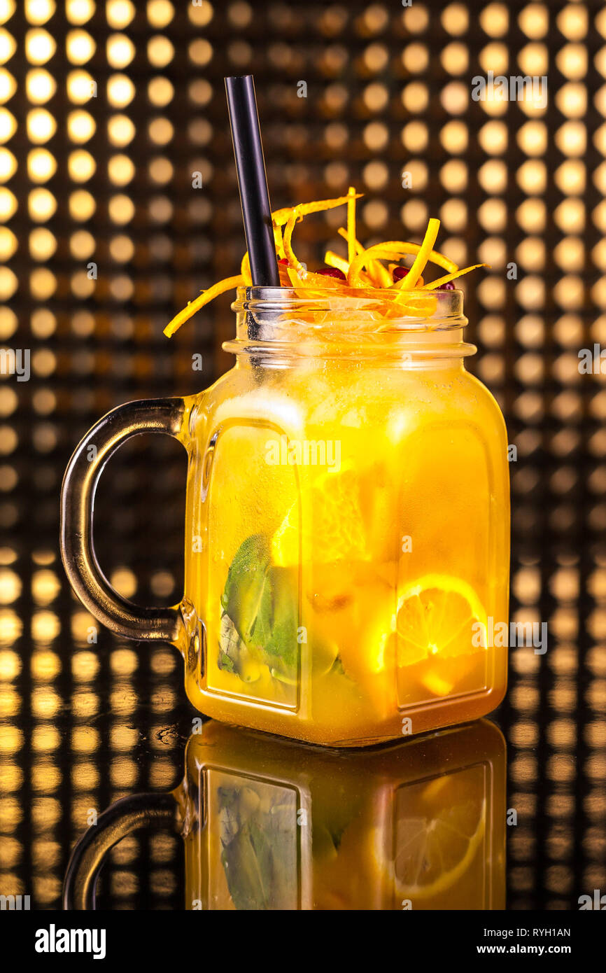 Yellow fruit cocktail lemonade with fresh lemon in vintage jar with ice ...