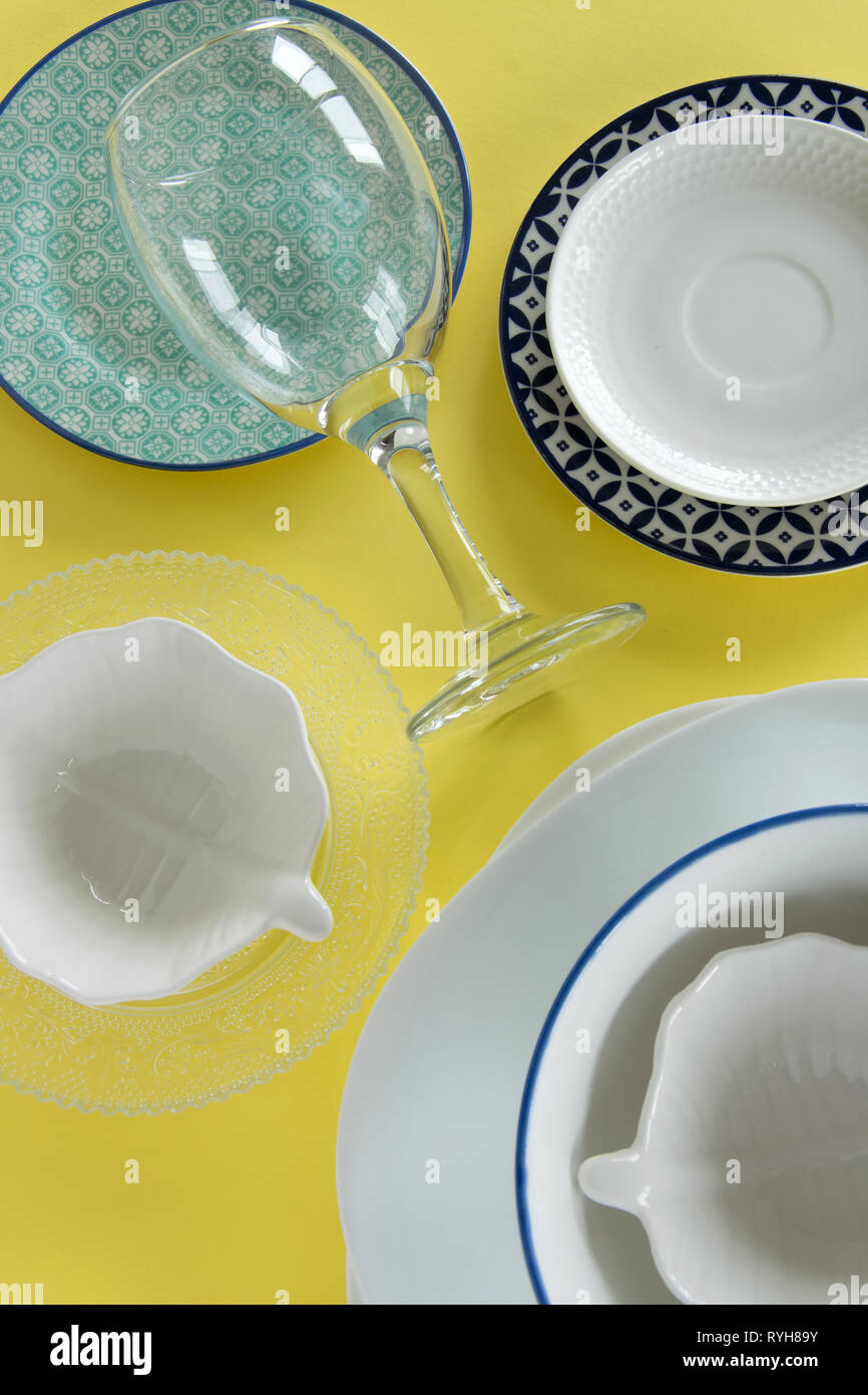 Different porcelain tableware on fresh yellow background Stock Photo ...