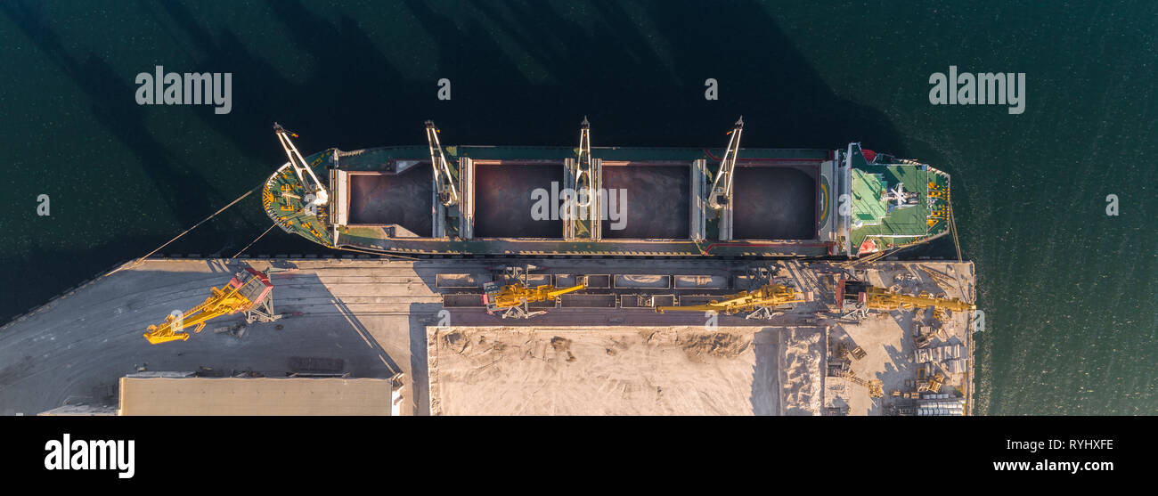 Top view of the port harbor with cargo ship on the pier and loading and ...