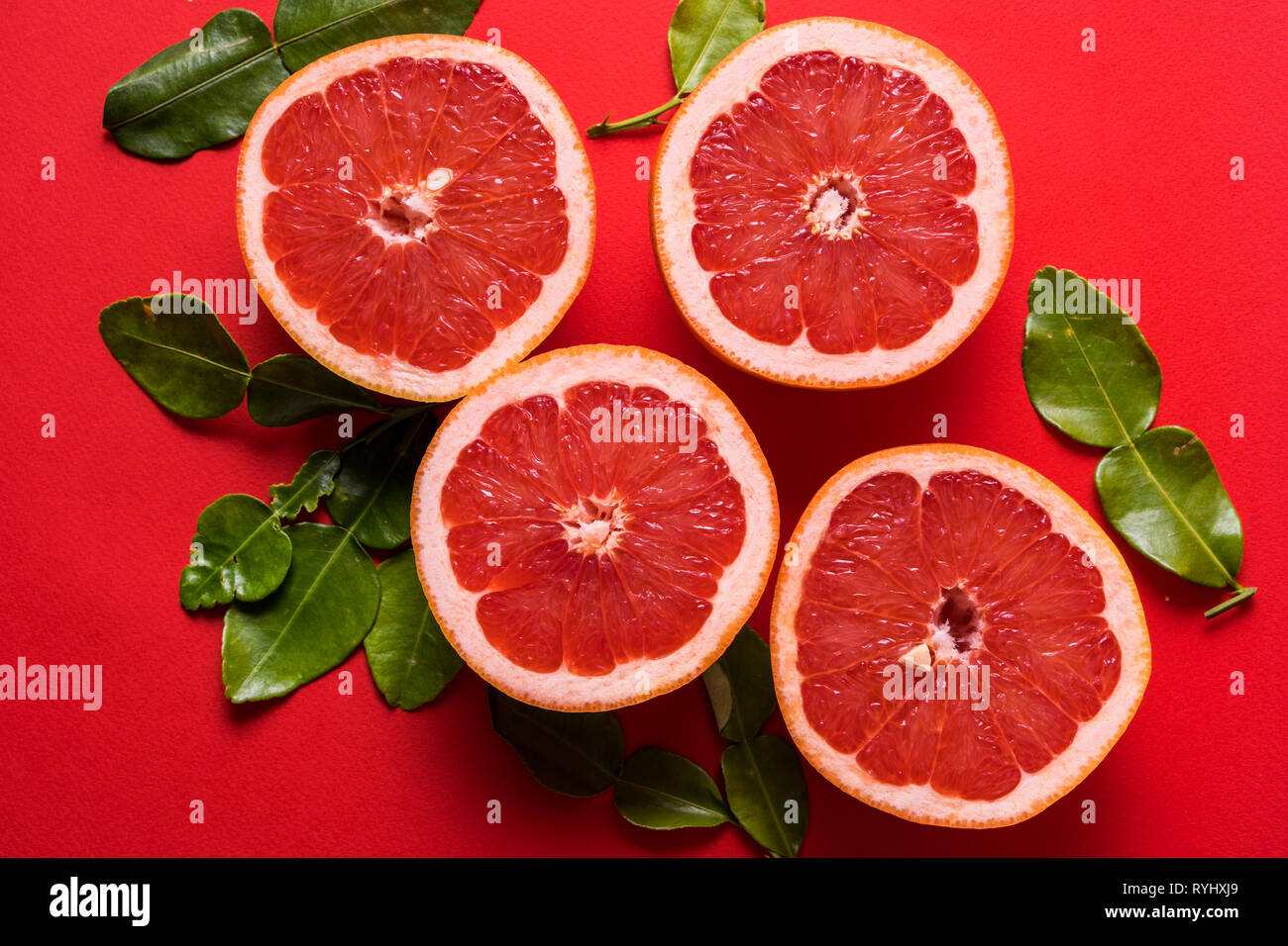 Healthy eating concept. Pattern with raw fresh red orange fruit with green leaves. Flat lay ...