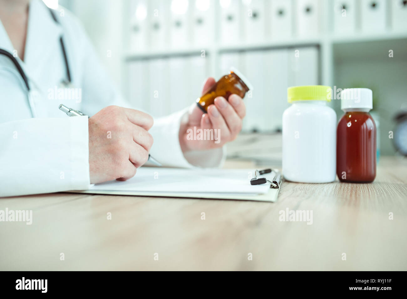 Doctor writing prescription for generic medicine drugs in medical ...
