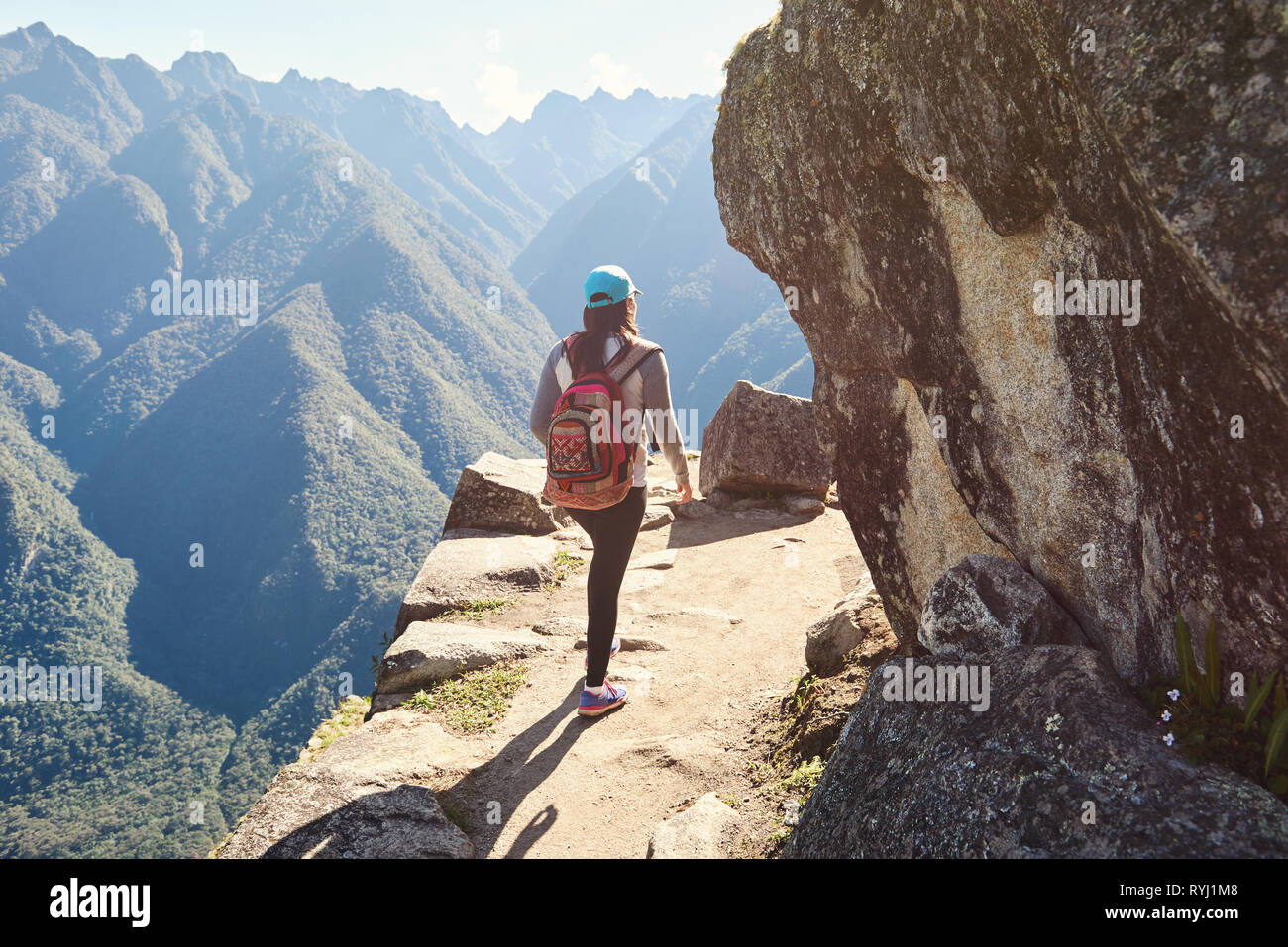 Woman walk on mountain cliff back view Stock Photo - Alamy