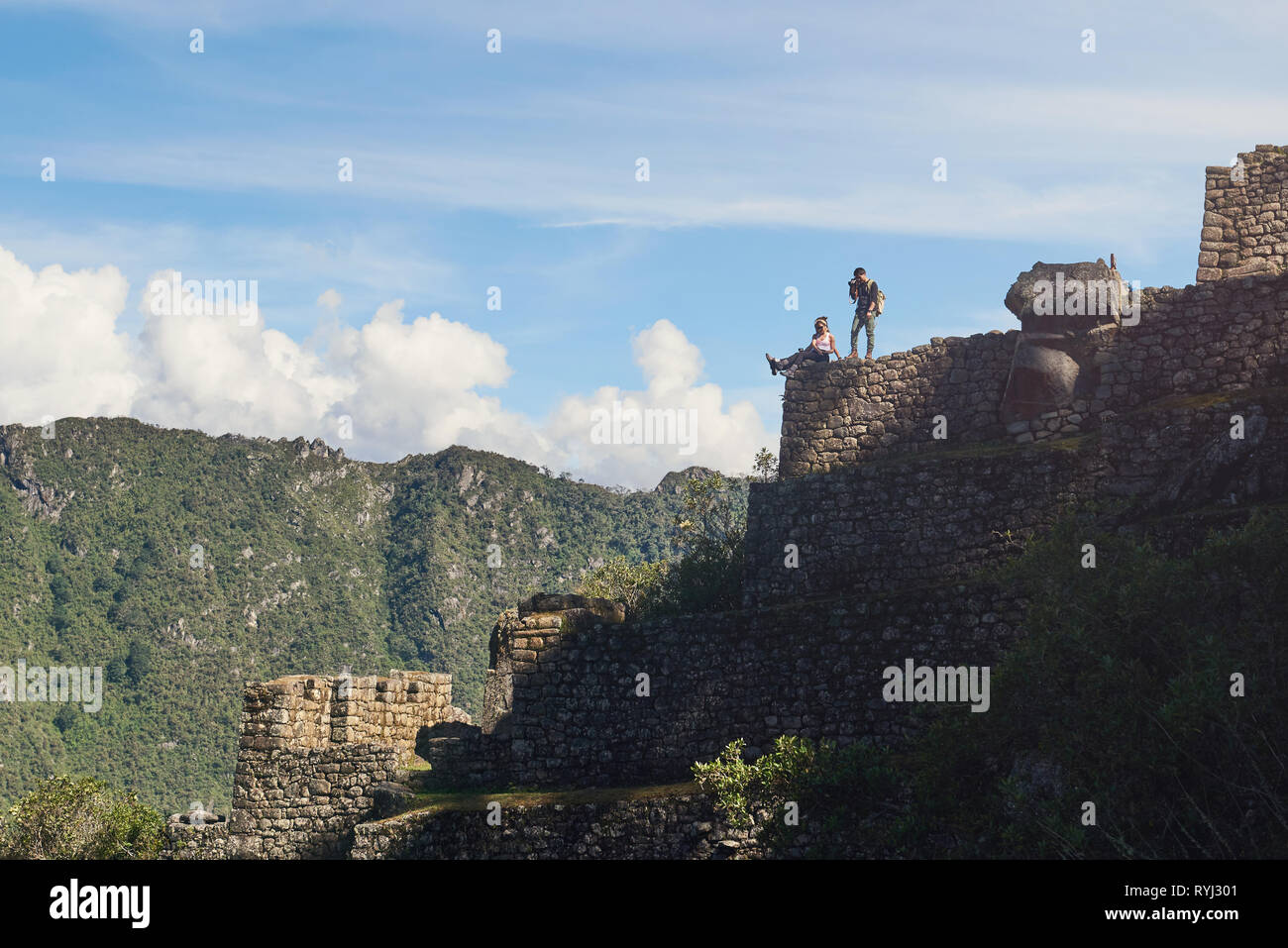 Machu Picchu, Peru - April 22, 2017: People sitting on edge of Machu ...