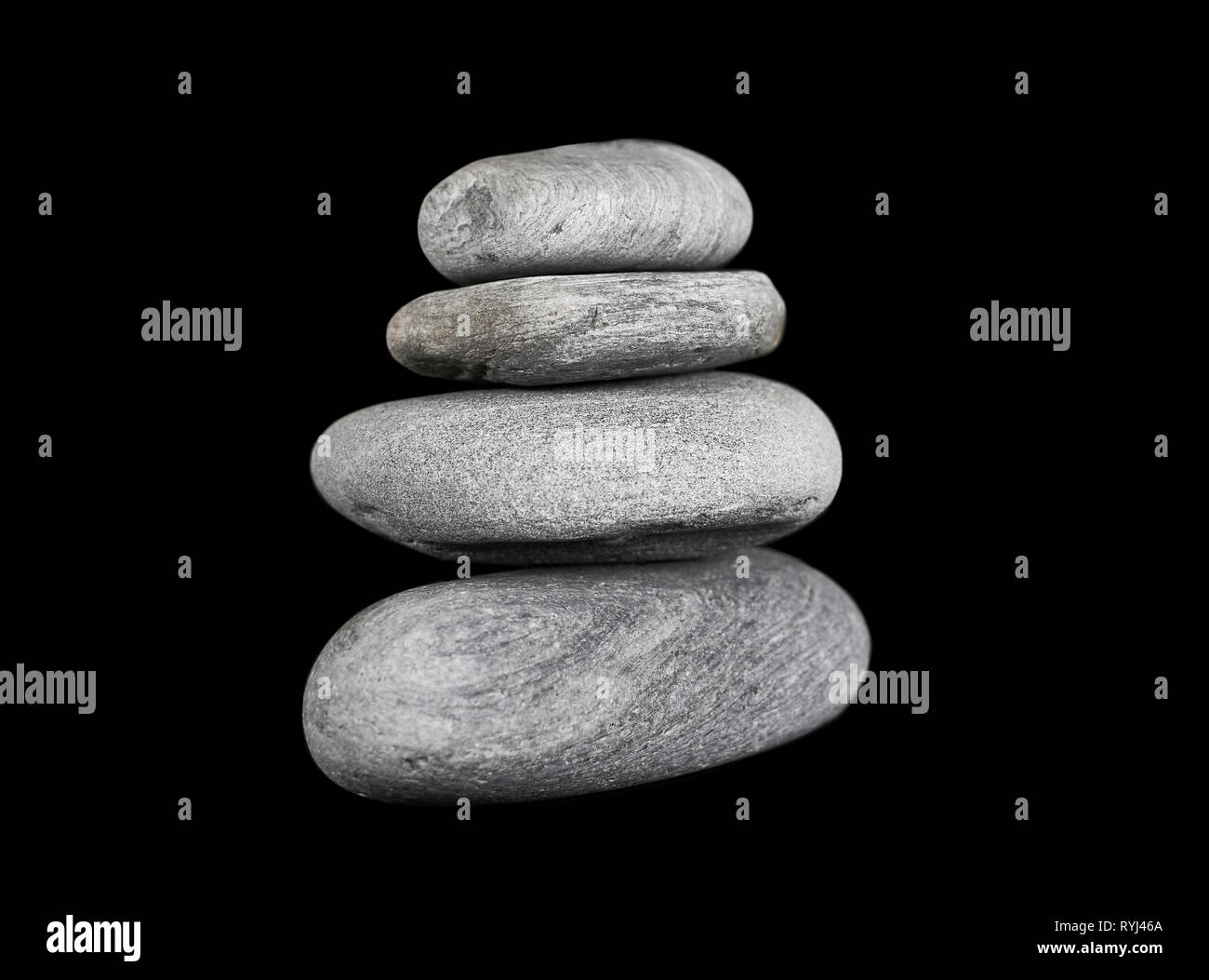 River rocks balanced on one another isolated on black Stock Photo - Alamy