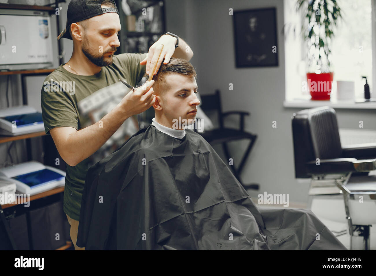 A man cuts hair in a barbershop Stock Photo - Alamy
