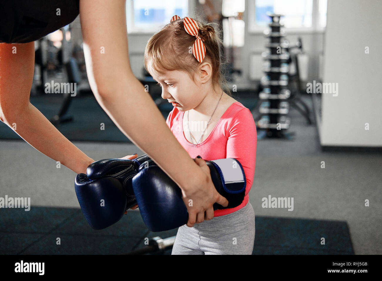 mom puts on boxing gloves in her daughter arms Stock Photo - Alamy