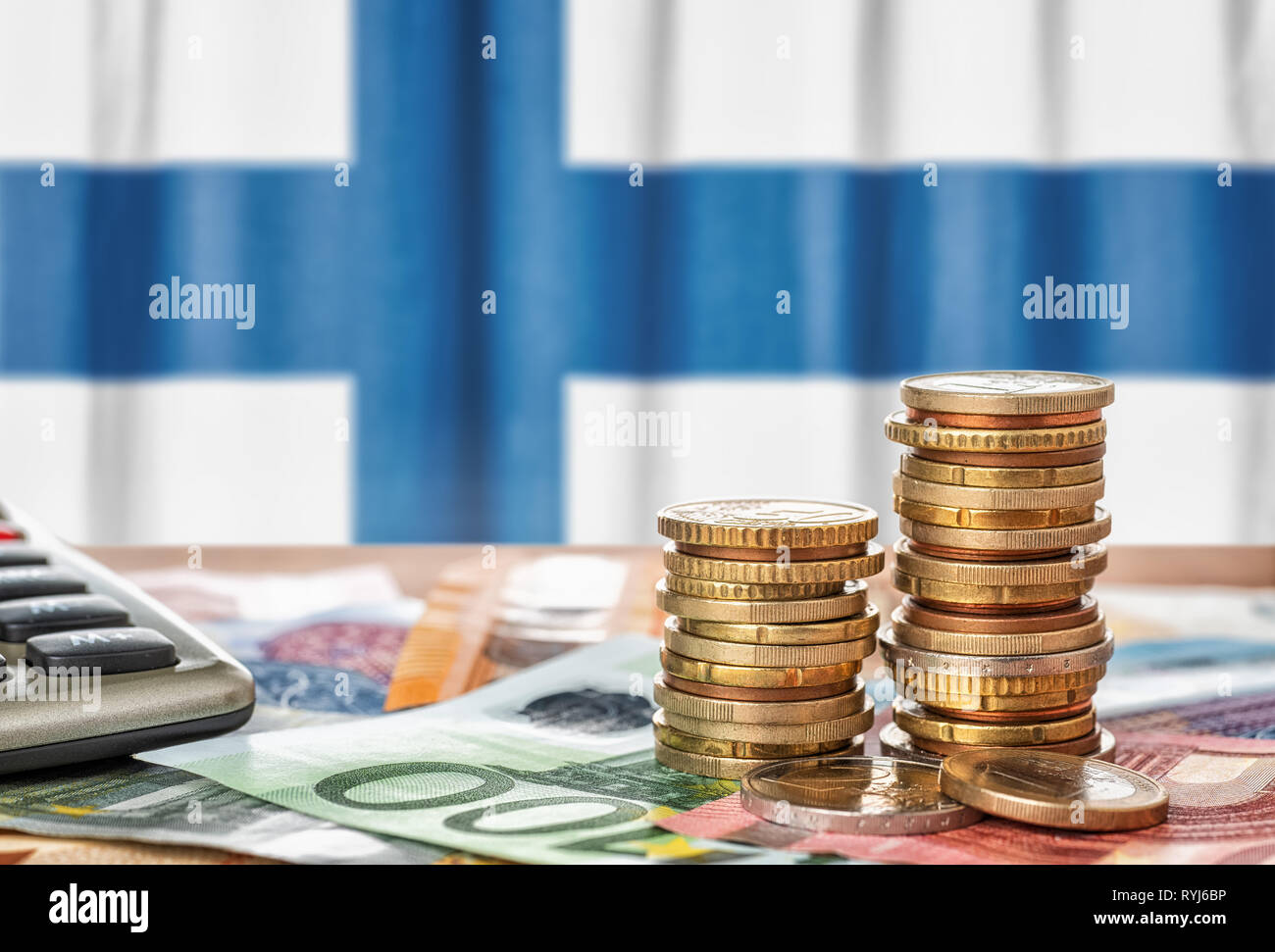 Euro banknotes and coins in front of the national flag of Finland Stock ...