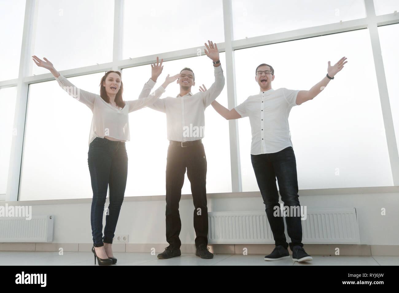 happy business team standing near office window Stock Photo - Alamy