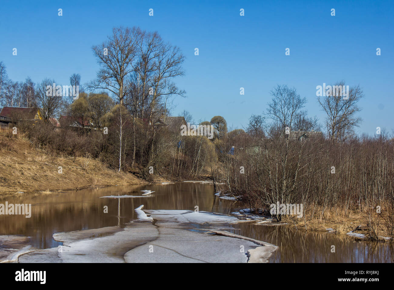 Melting ice on the river in the village. Country landscapes. Ice floats ...