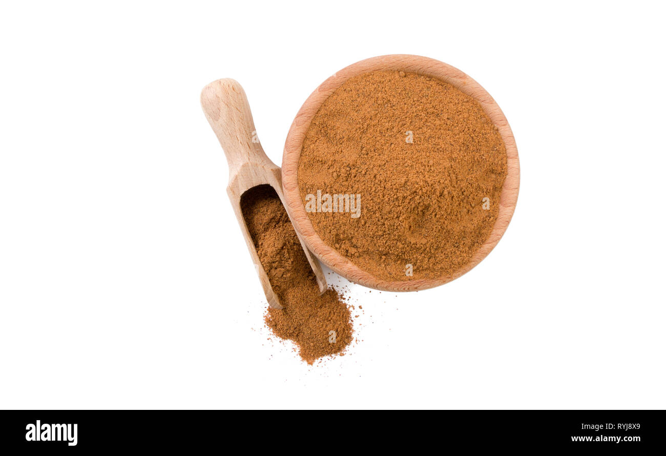 milled or ground nutmeg in wooden bowl and scoop isolated on white ...