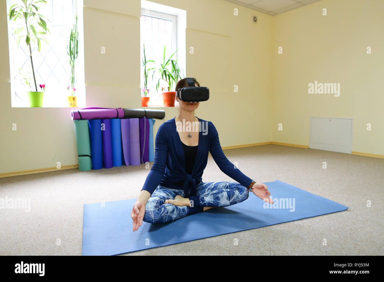 Lady works mutters by phone at yoga. Busy girl doing sports in light ...