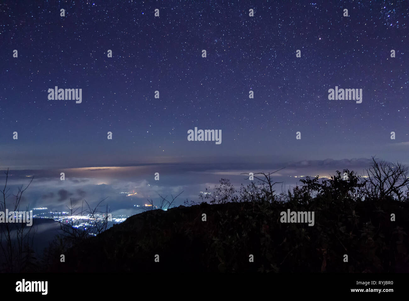Night view with stars over clouds and the mountain Stock Photo - Alamy