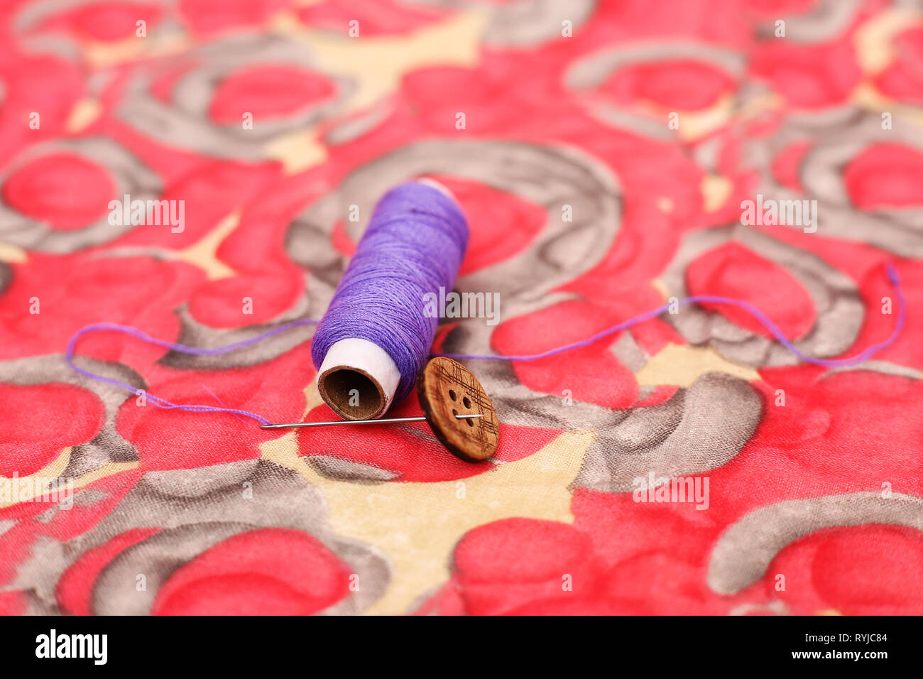 Photo of purple sewing thread, needle and button. Isolated on the ...