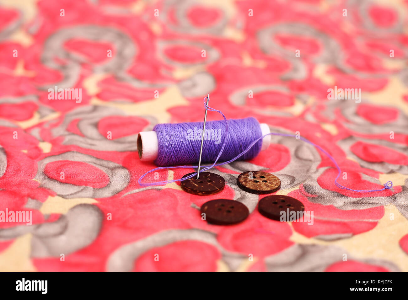 Picture of purple sewing thread, needle and four button. Isolated on ...