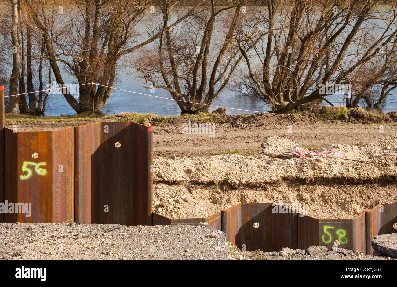 Steel pillar hitting in the ground to stabilizes the flood protection ...
