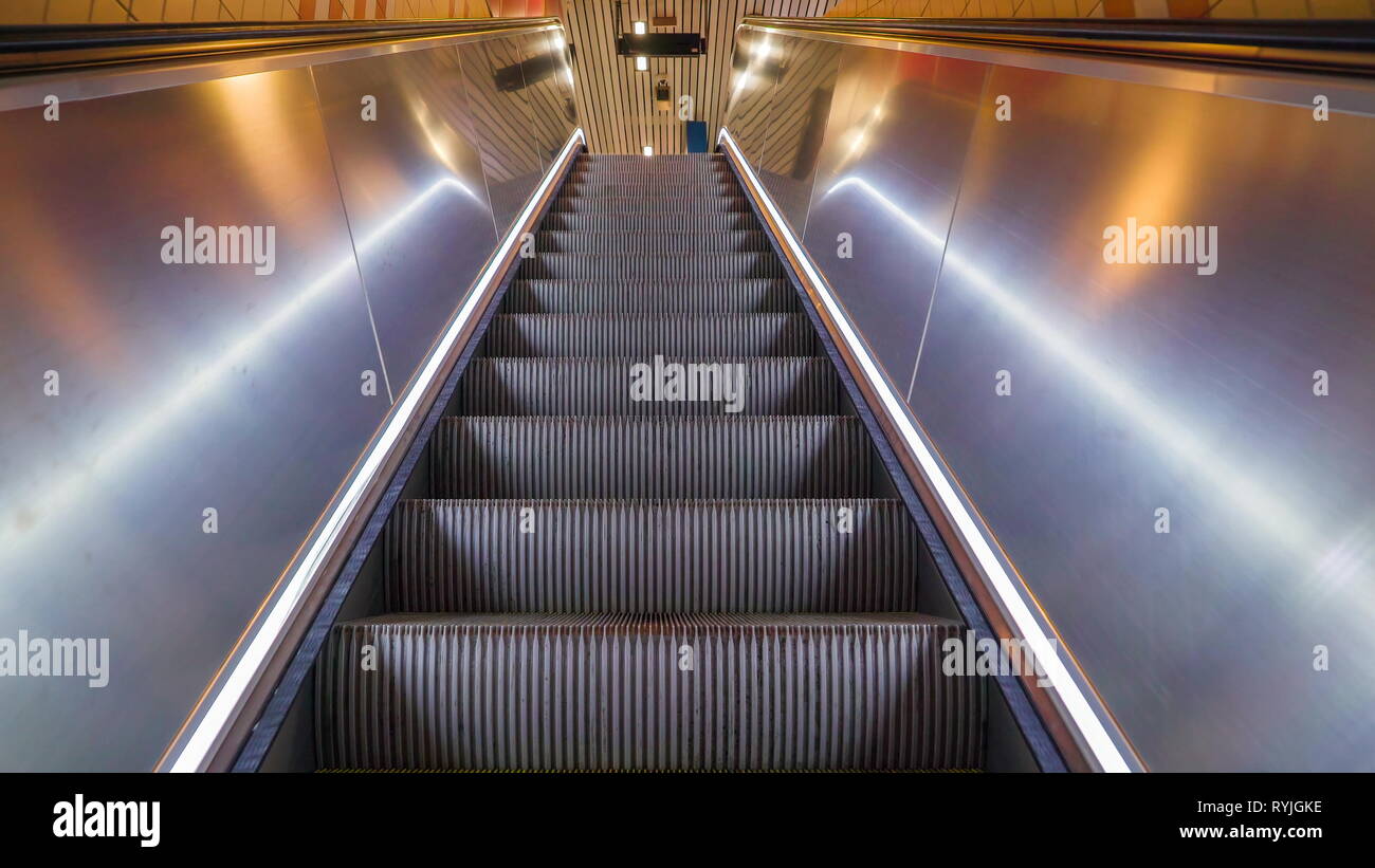 The going up escalator of the building with the railing on the side ...