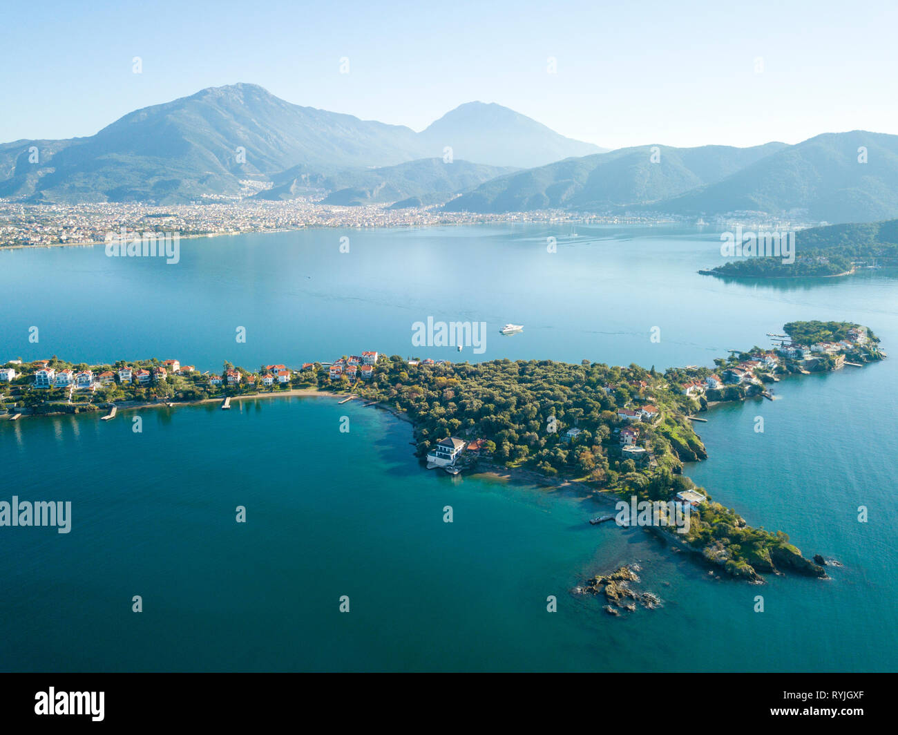 Drone aerial view of mountains and city behind Fethiye Adasi Island in ...