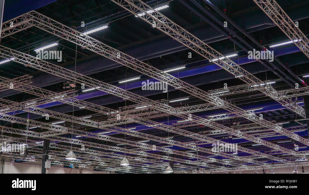 The metal scaffold ceiling of the building with the flourescnet lamps ...