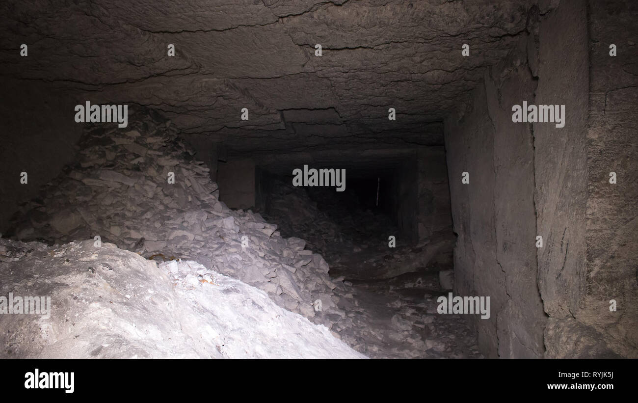 Old underground passage, dungeon, catacombs lined with stones and slabs ...