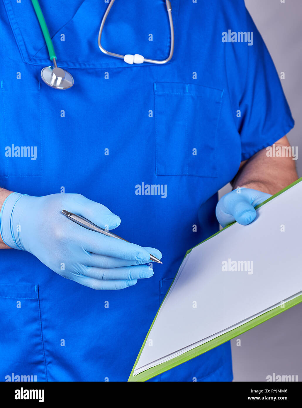 doctor in blue uniform holds a pen and paper holder in his hand ...