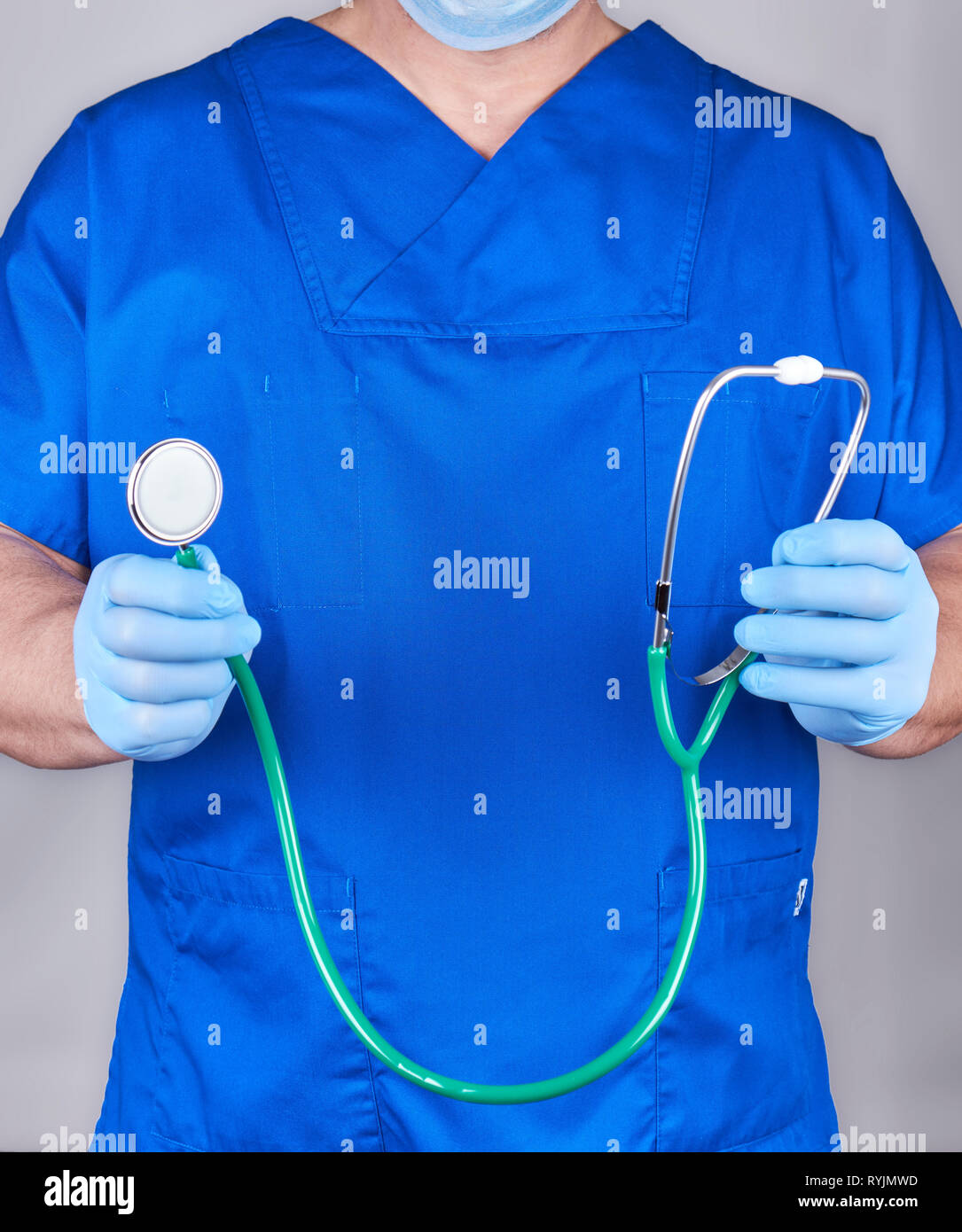 doctor in blue uniform and latex gloves holding a stethoscope Stock ...