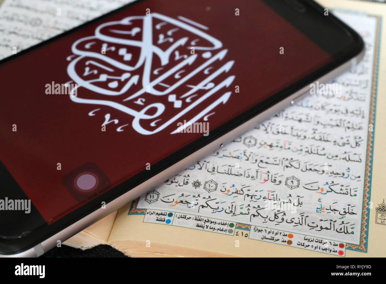 Digital quran on a smartphone and Holy Quran book. Close-up Stock Photo ...