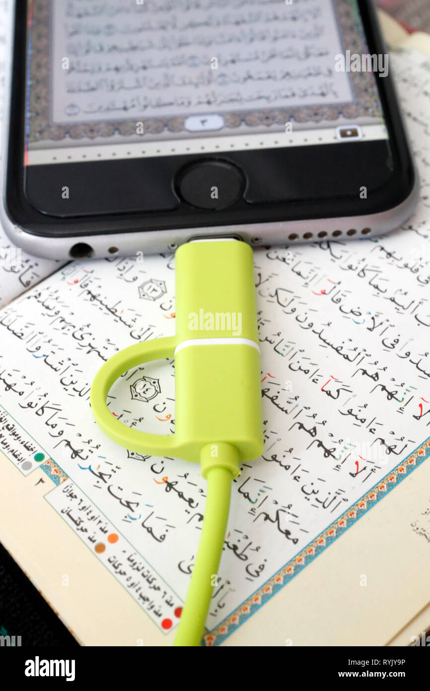 Digital quran on a smartphone and Holy Quran book. Close-up Stock Photo ...