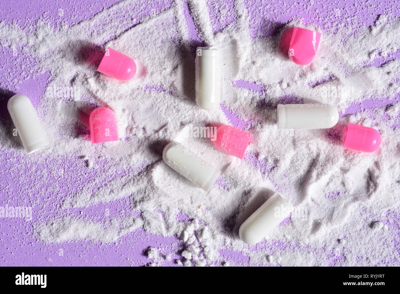 capsules pills broken with your powder medication on violet background ...