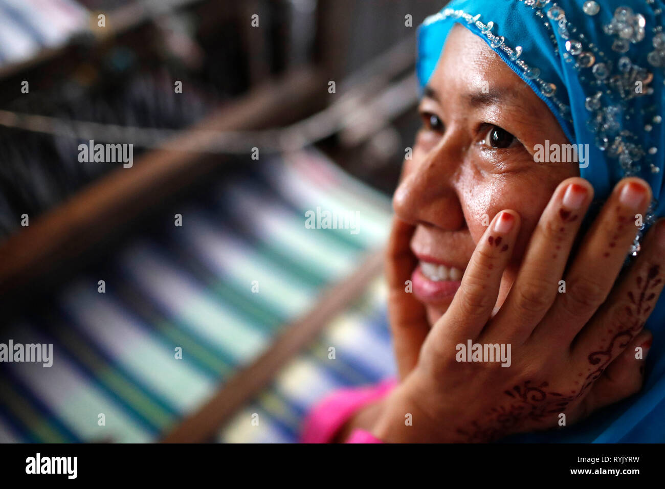 Traditional hand loom. Local muslim woman diligently weaving colourful ...