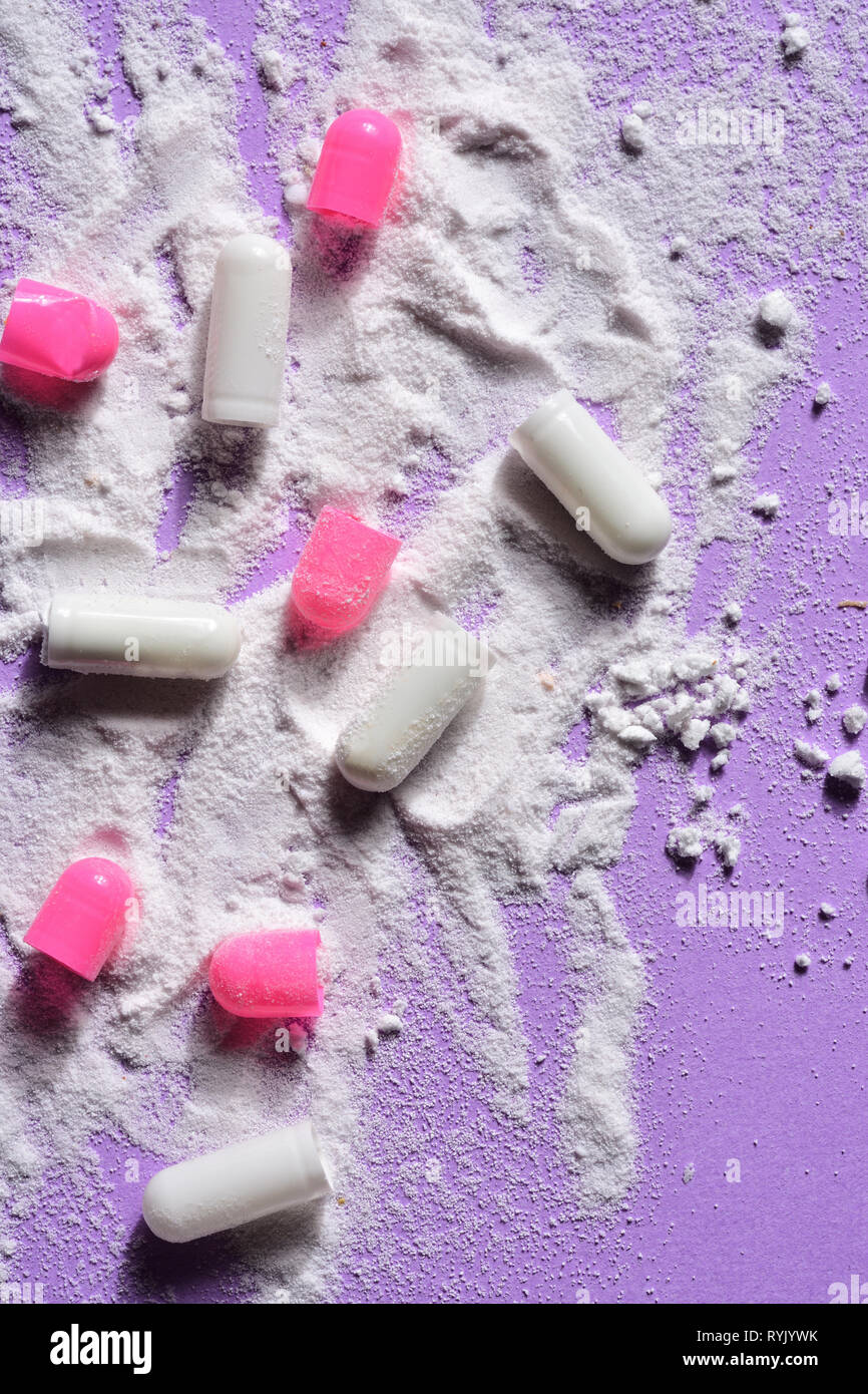 capsules pills broken with your powder medication on violet background ...