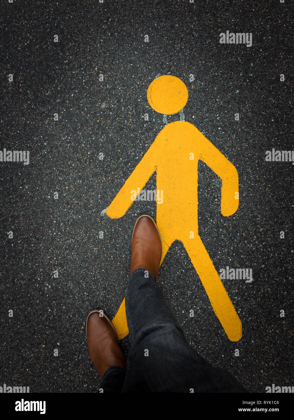 pedestrian sign on pavement with feet Stock Photo - Alamy