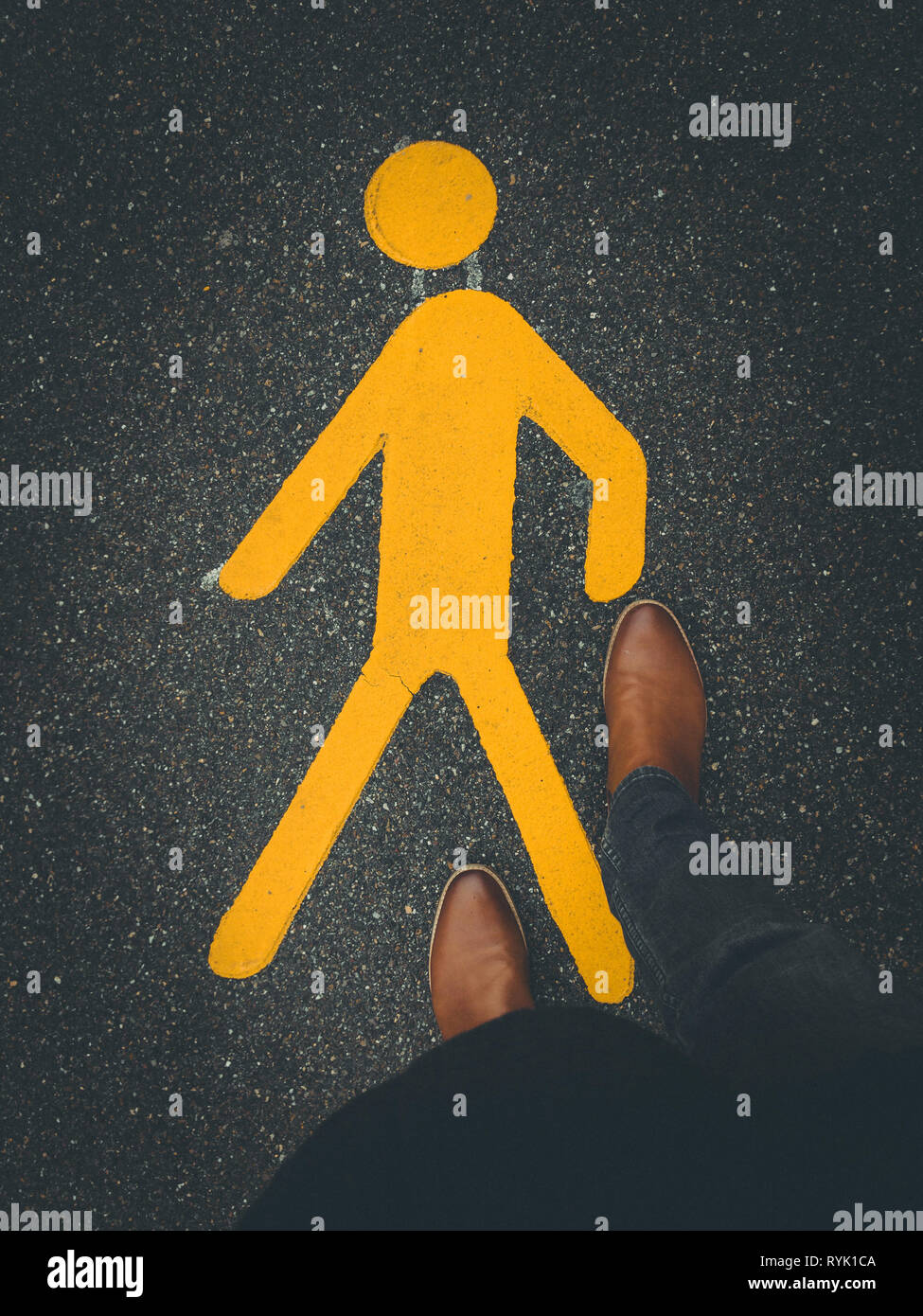yellow pedestrian sign on pavement with feet Stock Photo - Alamy