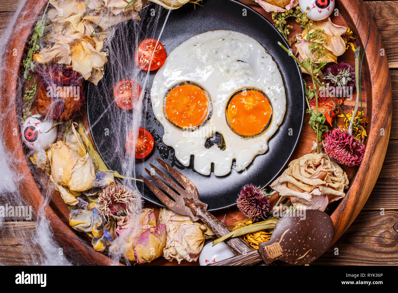 Fried eggs in the shape of a skull and fresh tomatoes. Breakfast in ...