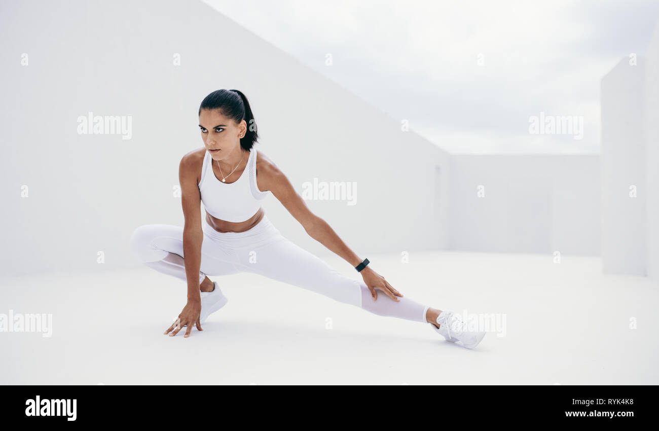 fitness woman doing stretching exercises. Woman in white fitness wear ...