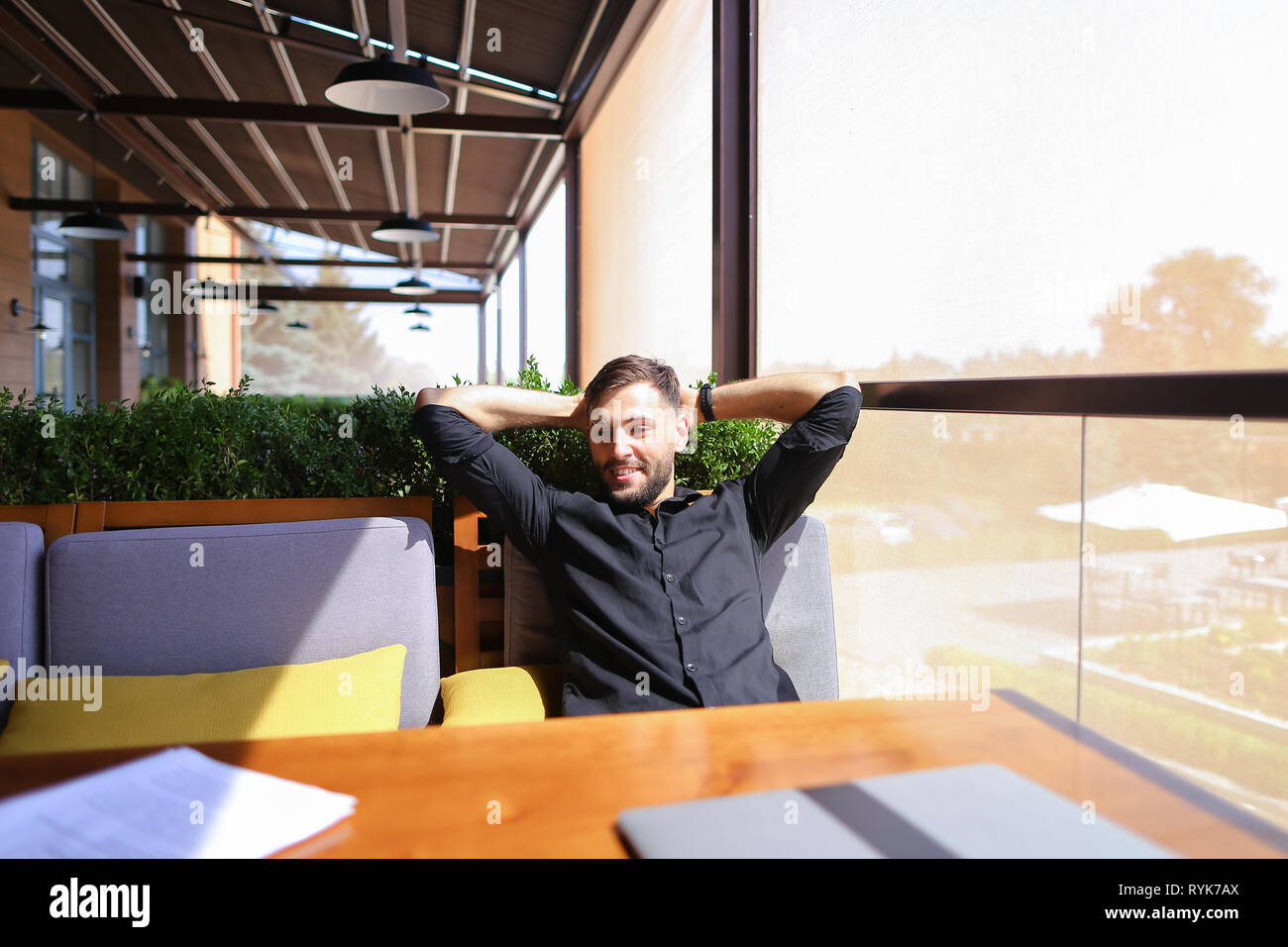 European translator sorting papers and closing laptop lid at cafe ...