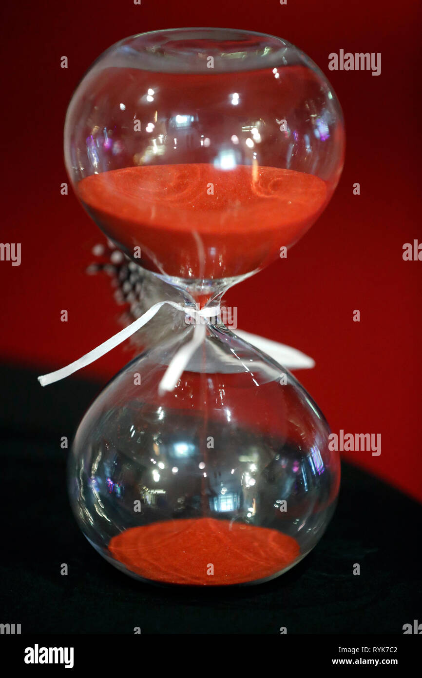 Red sand in an hourglass. France Stock Photo - Alamy