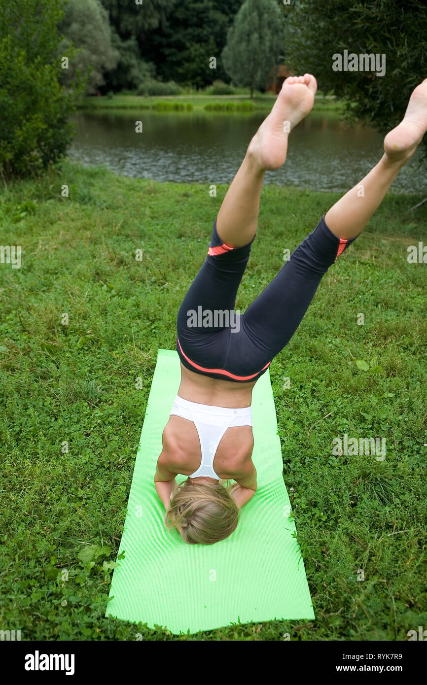 An unsuccessful attempt by a girl to perform a yoga pose. Healthy ...