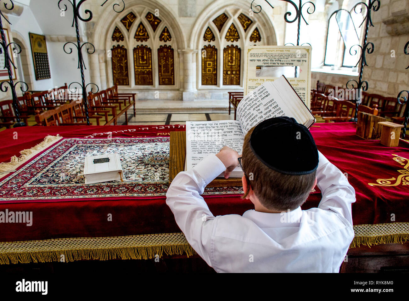 The 4 sephardic synagogues, Jerusalem old city, Israel. Boy reading at ...