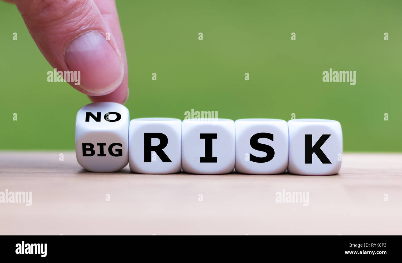 Hand turns a dice and changes the expression "big risk" to "no risk ...