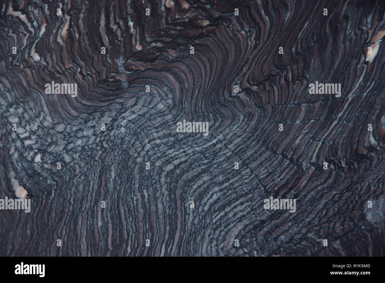 Wavy pattern, like circles on the water on a dark natural stone called ...