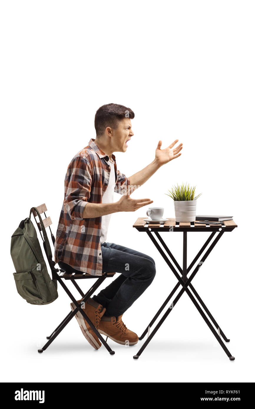 Full length profile shot of an angry male student in a cafe shouting ...