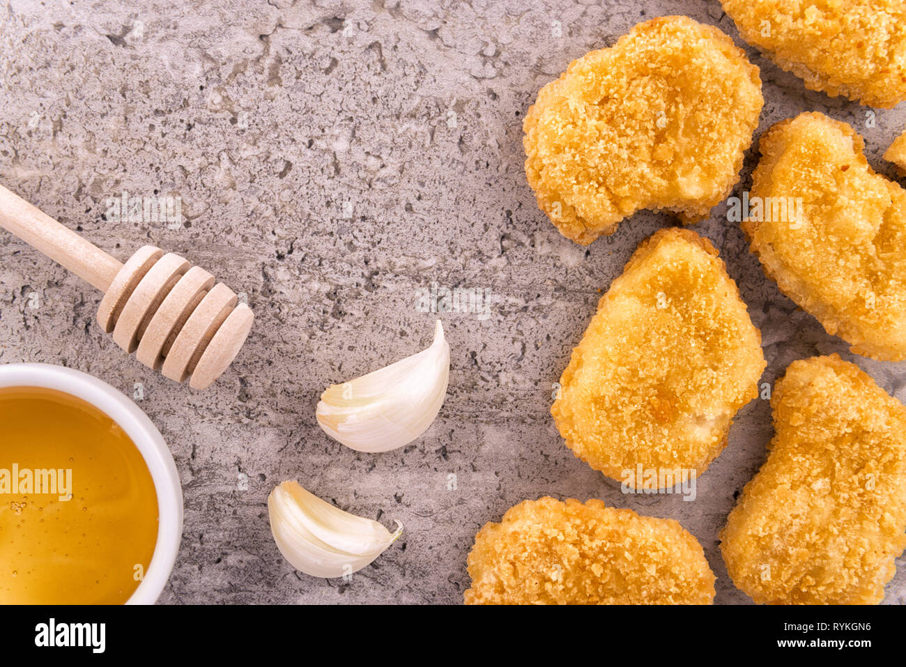 Chicken nuggets with garlic and honey on a concrete texture background ...