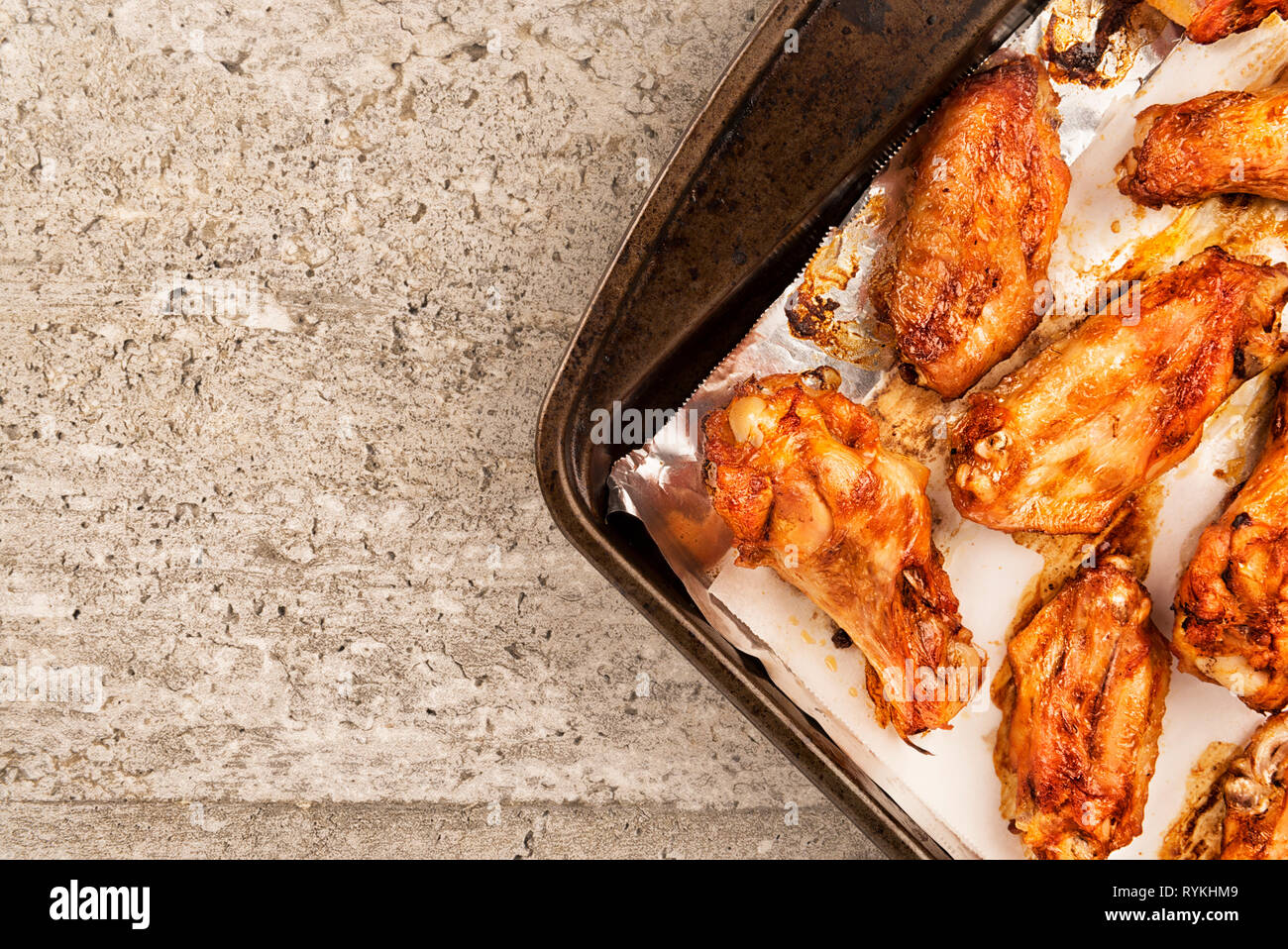 Barbecue chicken wings on an old cooking pan, concrete texture in ...