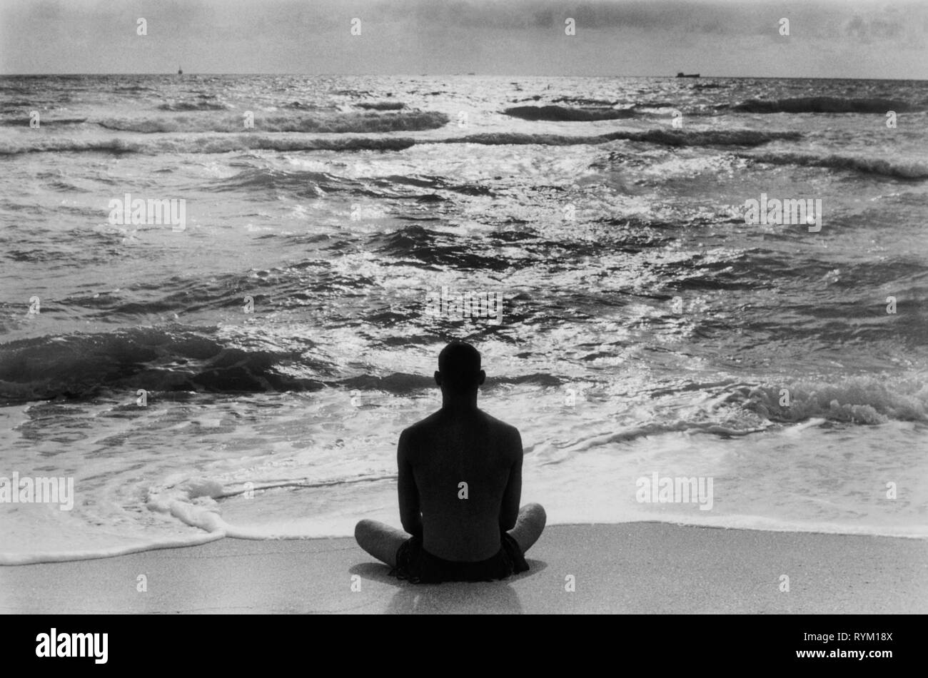 South Beach Miami Florida - USA June 1999. A lone man sits on the beach ...