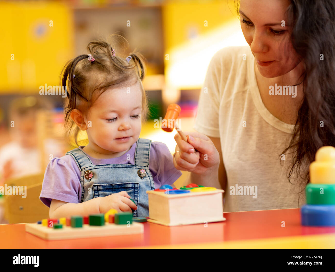 cute baby play with babysitter in nursery or kindergarten Stock Photo ...