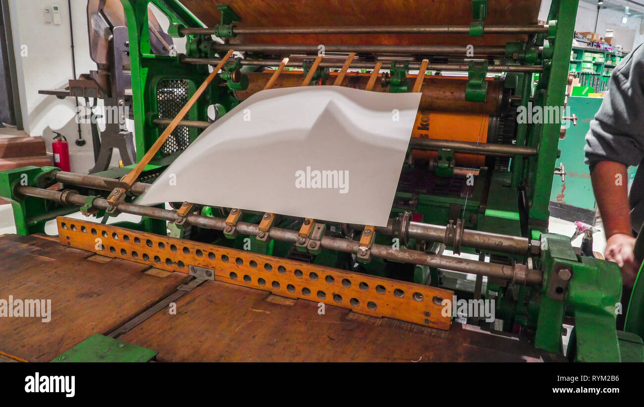 The big old manual printing machine inside the factory being operated ...