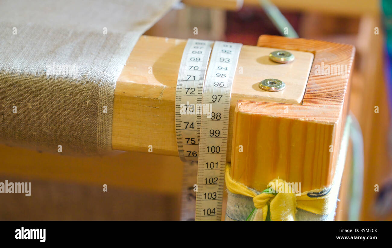 The yellow tape measure rolled around the wood of the traditional ...