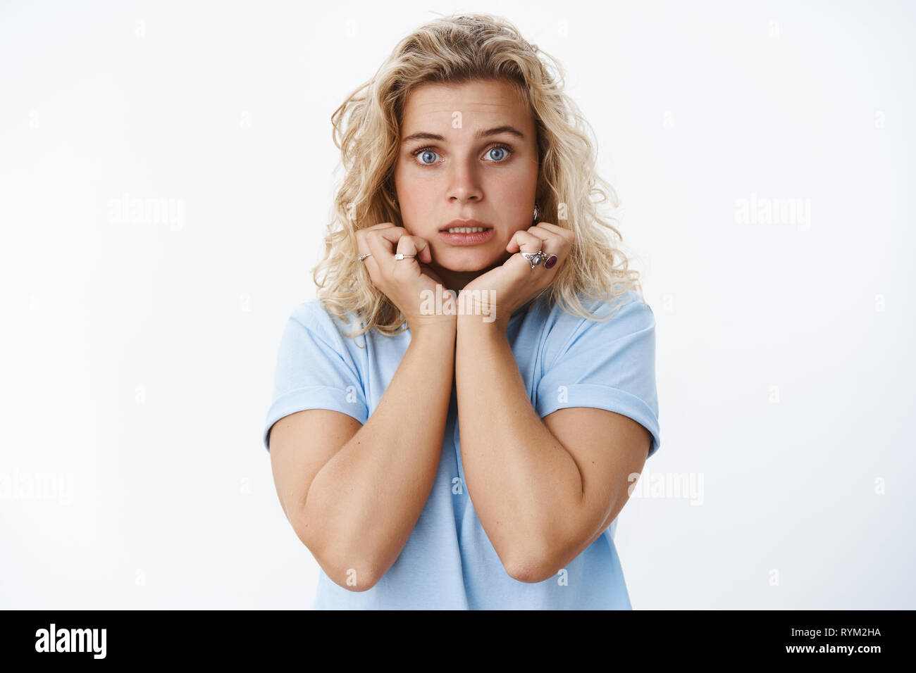 Close-up shot of insecure and silly scared cute female with blond hair ...